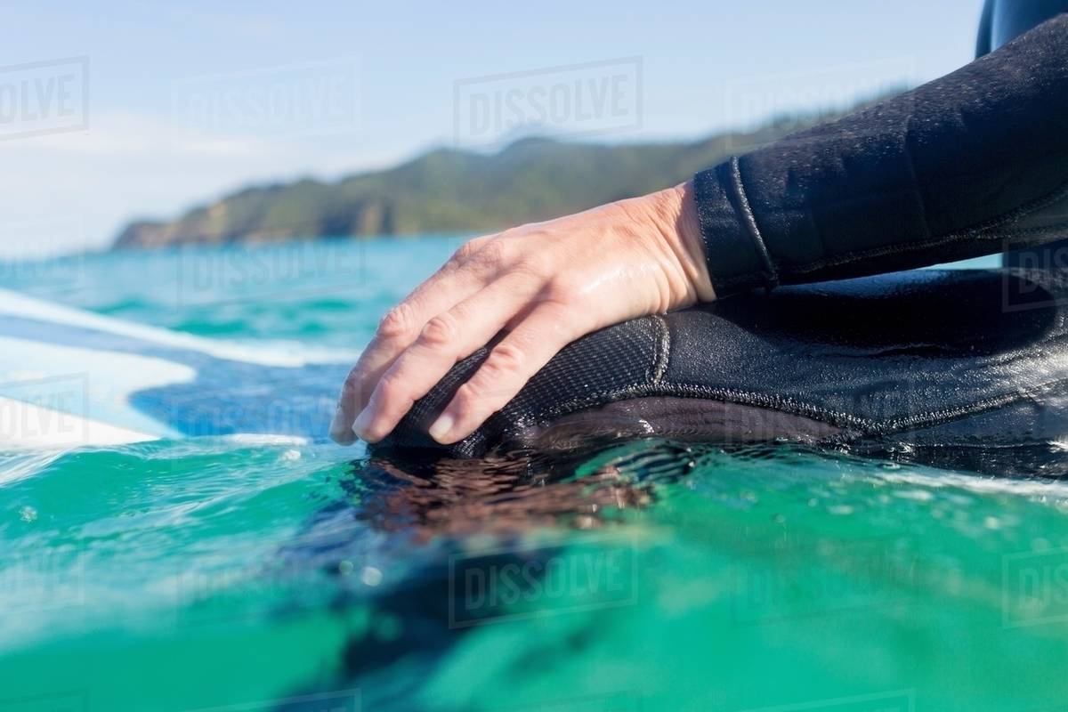 Hands of surfer in the water, Bay of Islands, NZ - Stock Photo - Dissolve