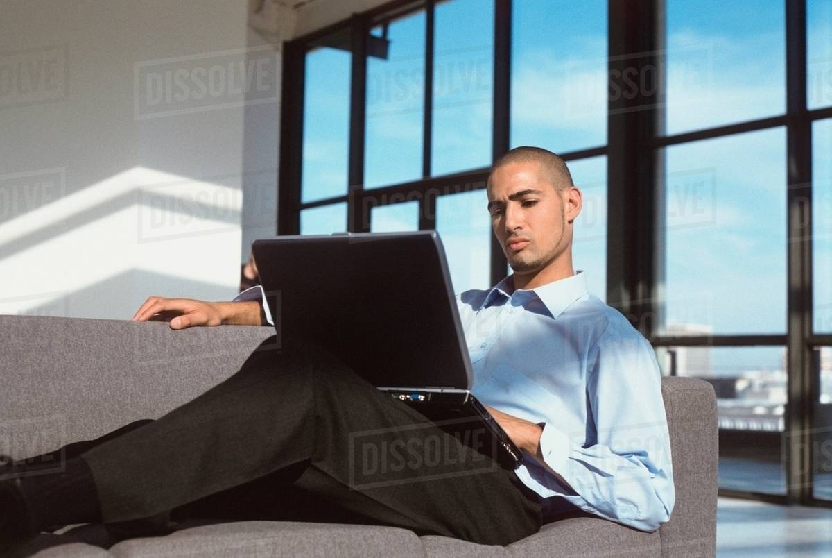 Businessman using laptop on couch - Royalty-free Stock Photo | Dissolve