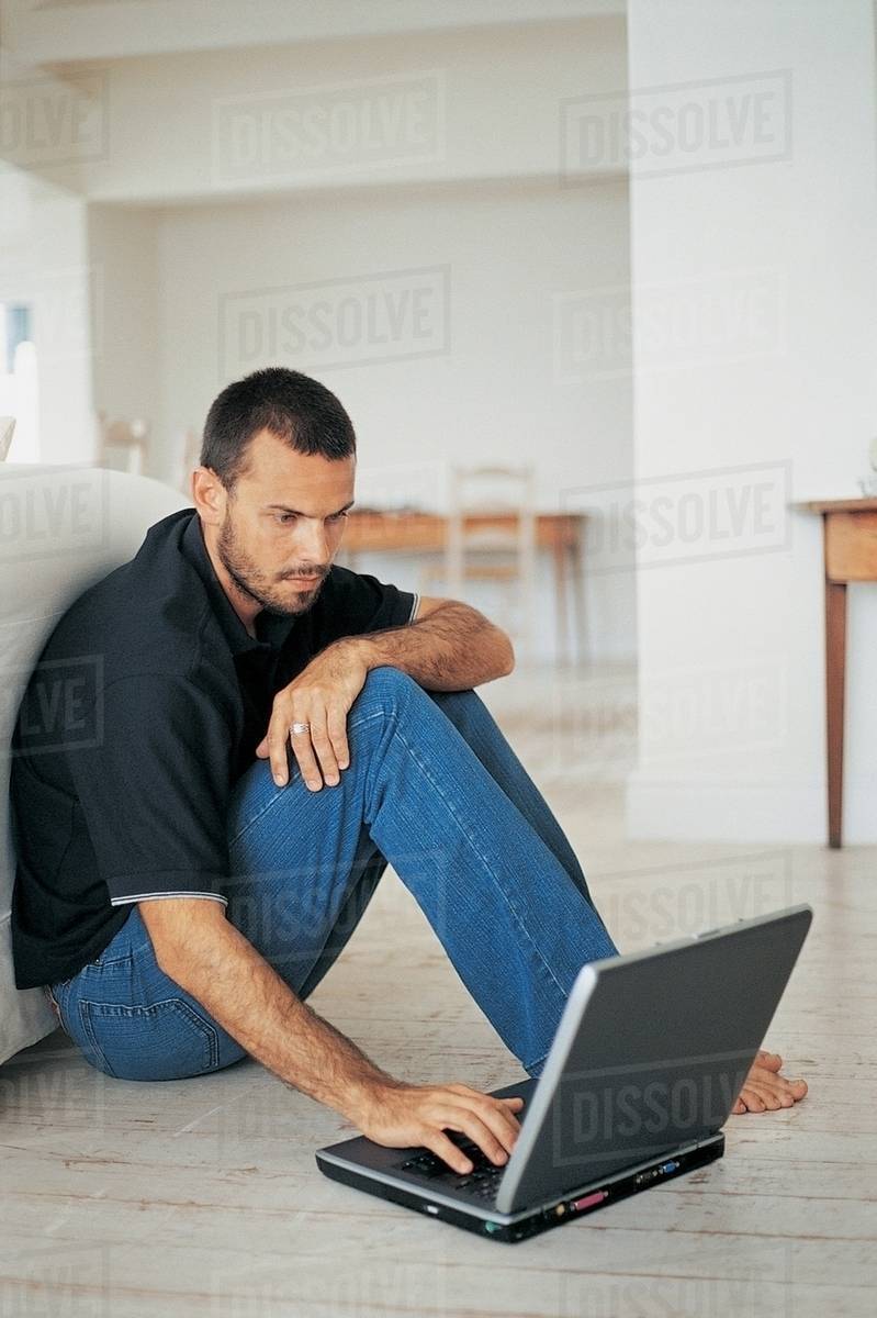 Man using laptop on floor - Royalty-free Stock Photo | Dissolve
