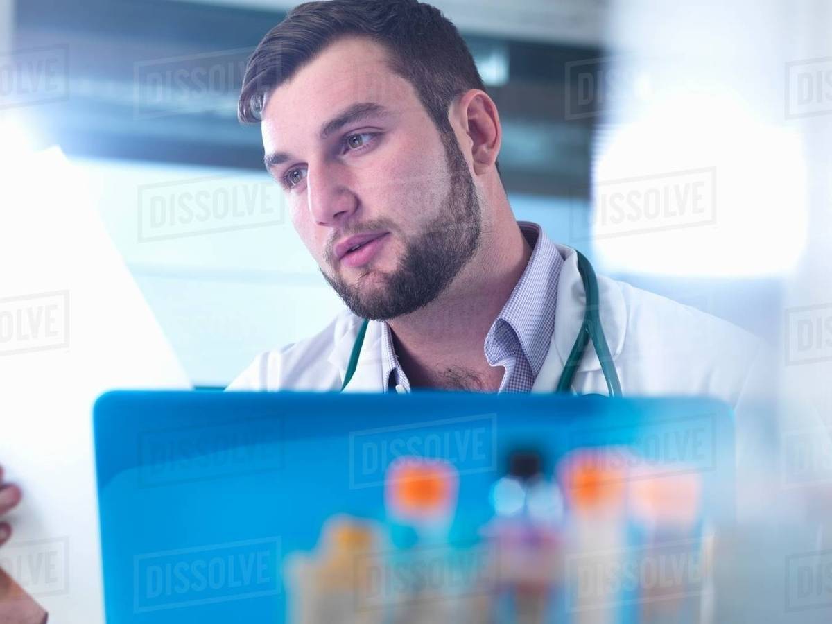 Doctor reading patient medical test results, samples in foreground ...