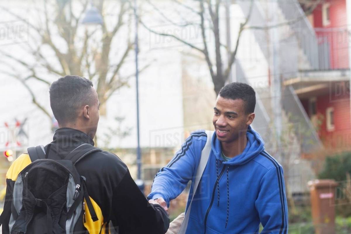 Twin brothers shaking hands, outdoors - Royalty-free Stock Photo | Dissolve