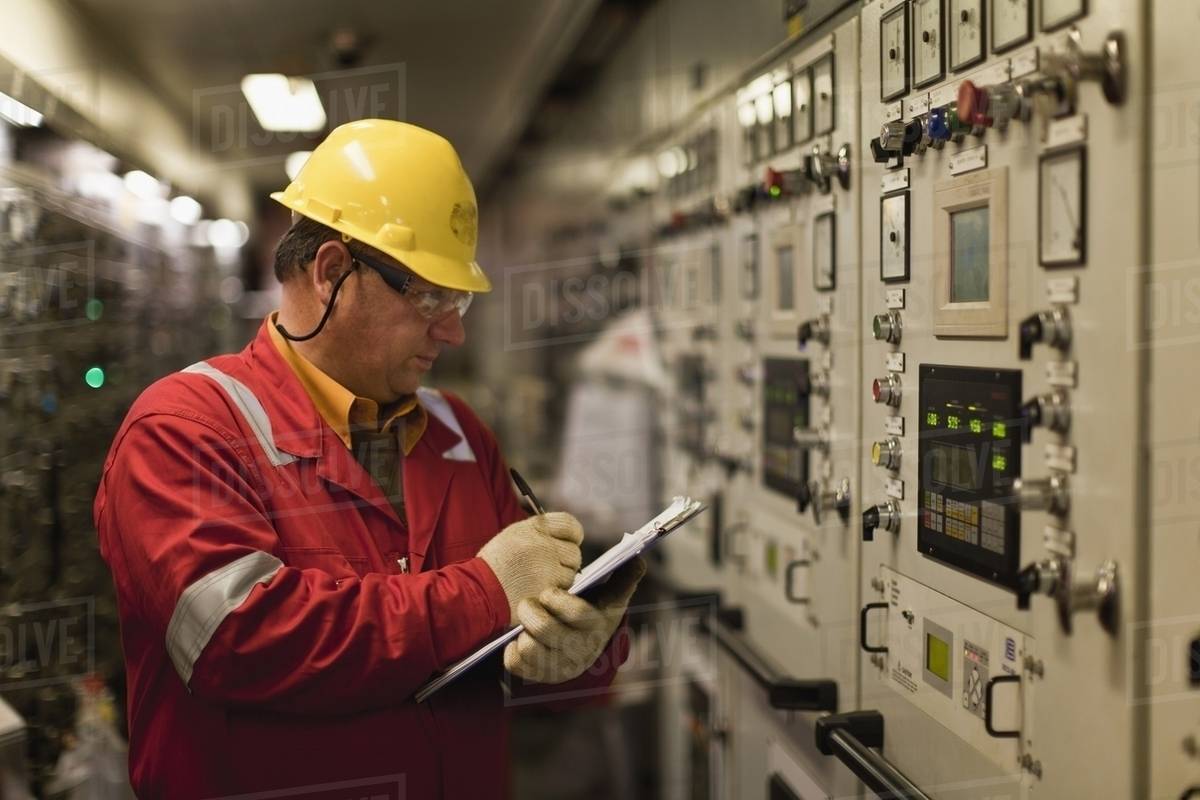 Worker checking machinery - Stock Photo - Dissolve