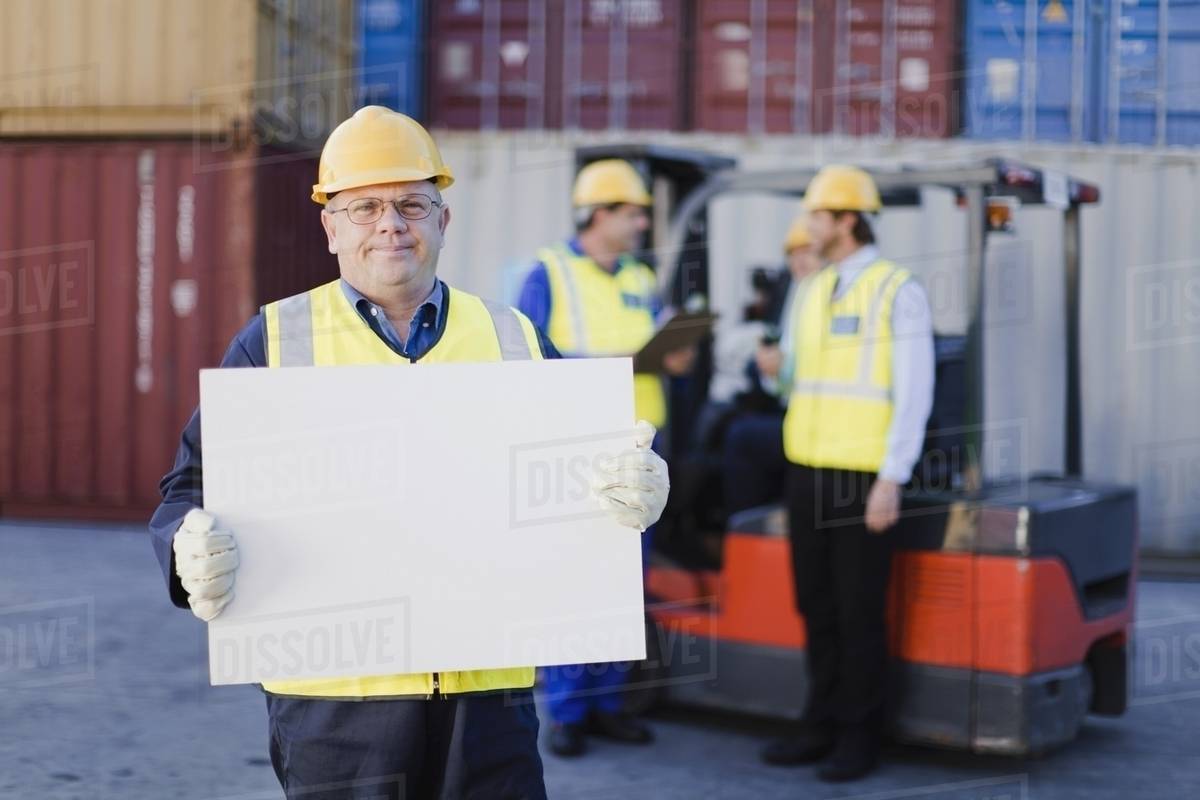 Worker holding sheet in shipping yard - Royalty-free Stock Photo | Dissolve