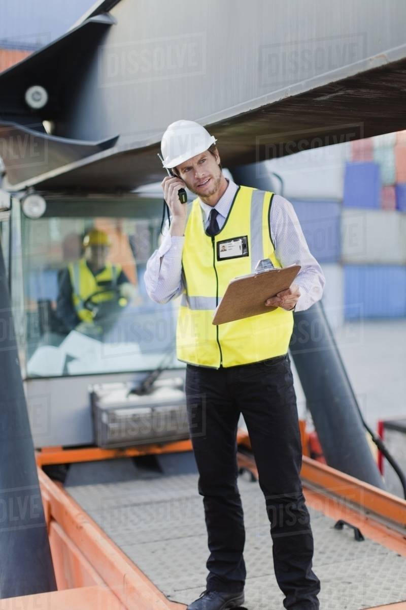 Worker standing on machinery on site - Stock Photo - Dissolve