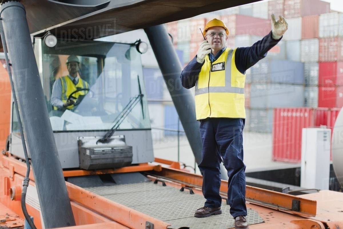 Worker directing machinery on site - Royalty-free Stock Photo | Dissolve