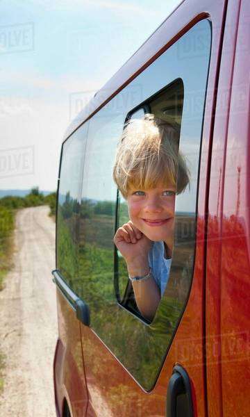 Boy peering out car window - Stock Photo - Dissolve
