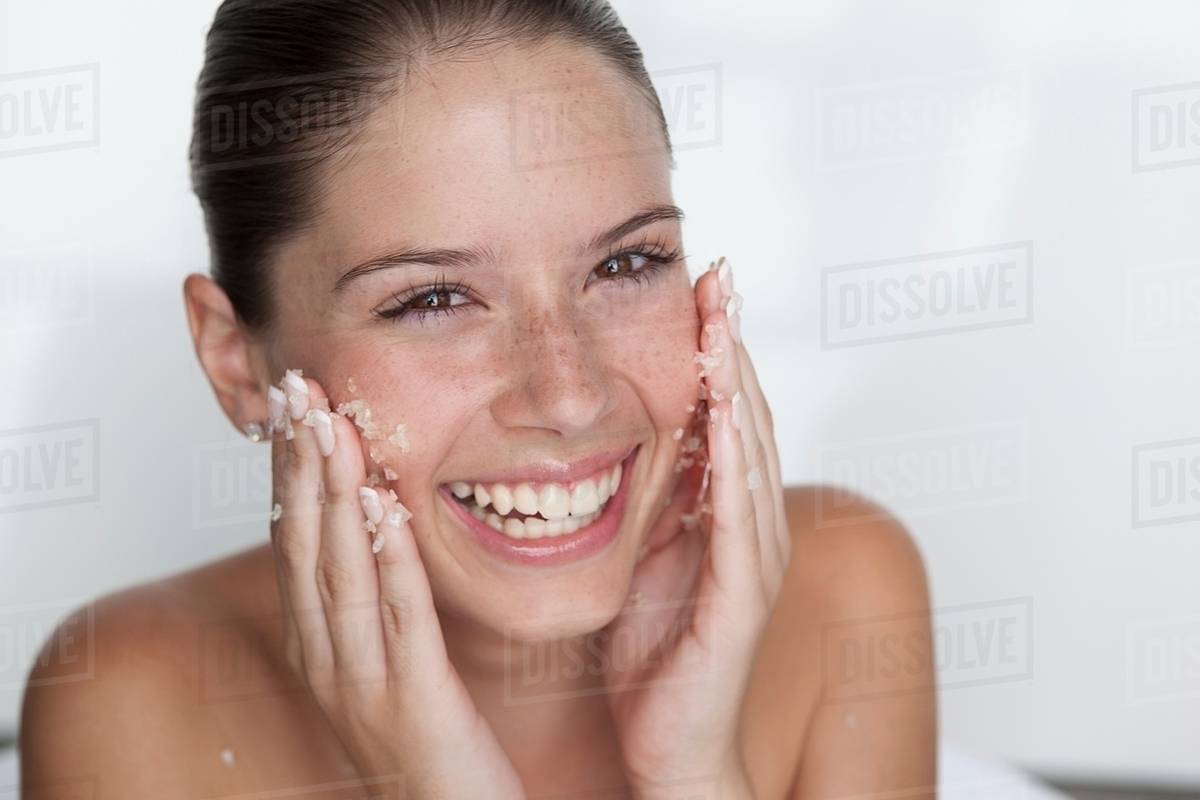 Woman scrubbing sugar on her face - Stock Photo - Dissolve