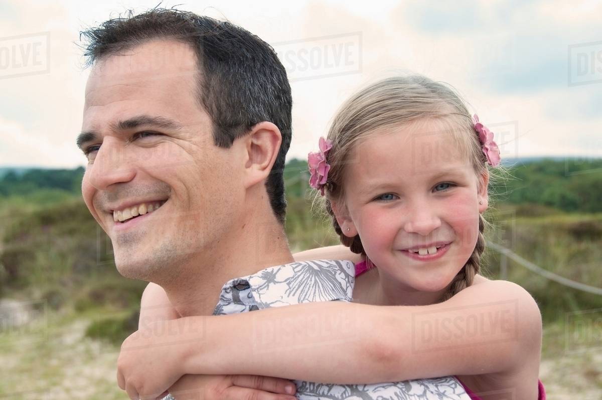 Father carrying daughter piggy back - Royalty-free Stock Photo | Dissolve