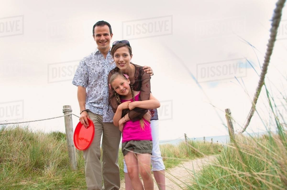 Family standing together on beach - Royalty-free Stock Photo | Dissolve