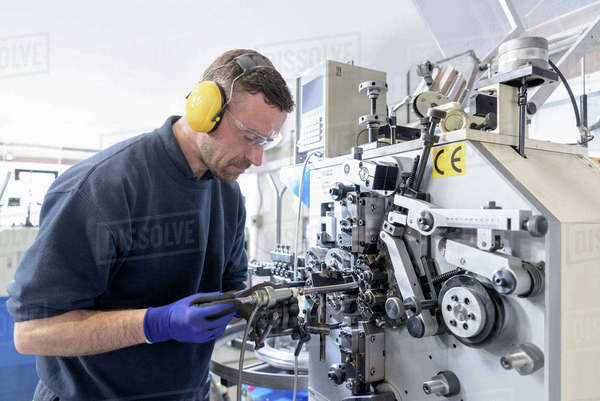 Engineer working with spring making machine in engineering factory ...