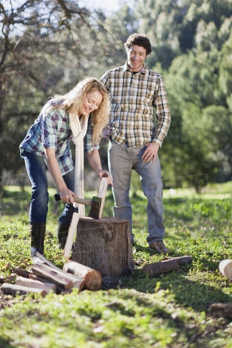 Woman chopping wood outdoors - Stock Photo - Dissolve
