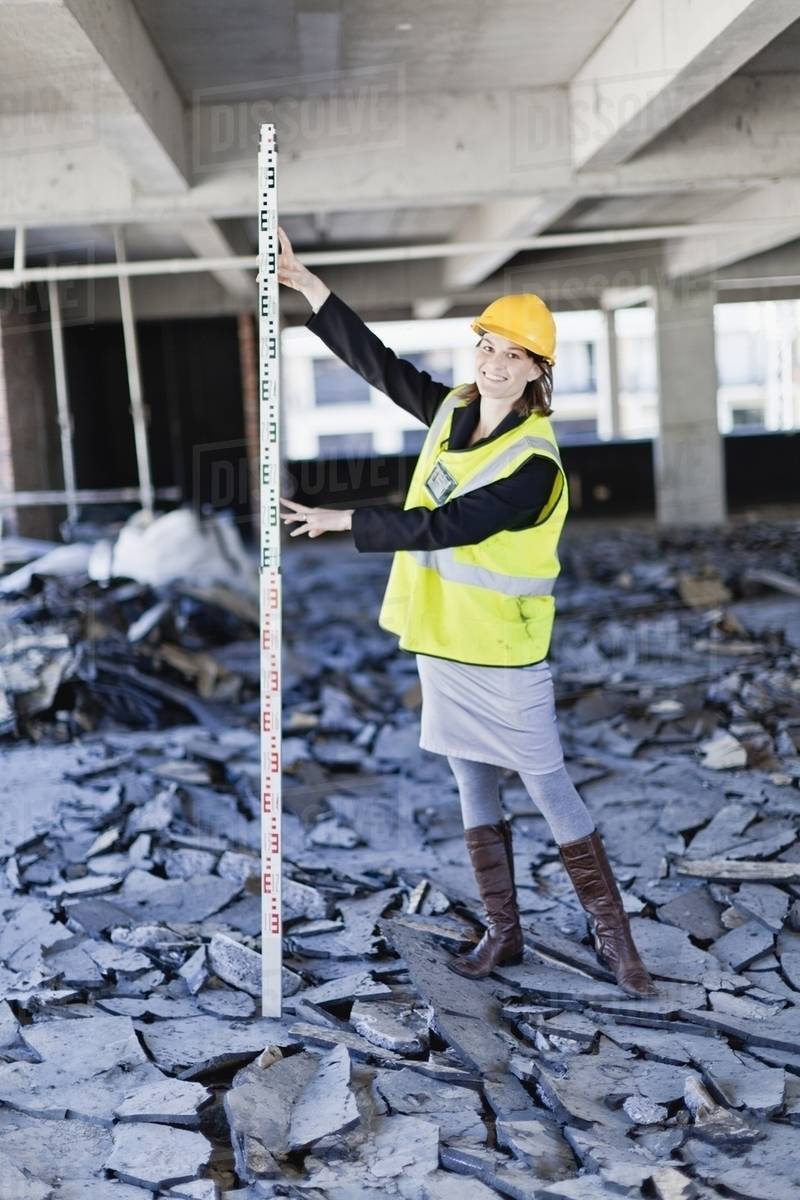 Worker measuring space on site - Stock Photo - Dissolve