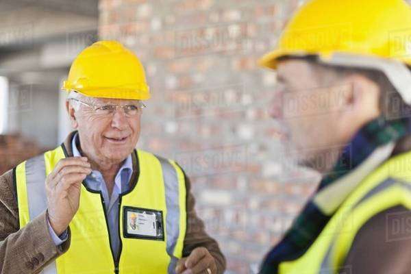 Construction workers talking on site - Stock Photo - Dissolve