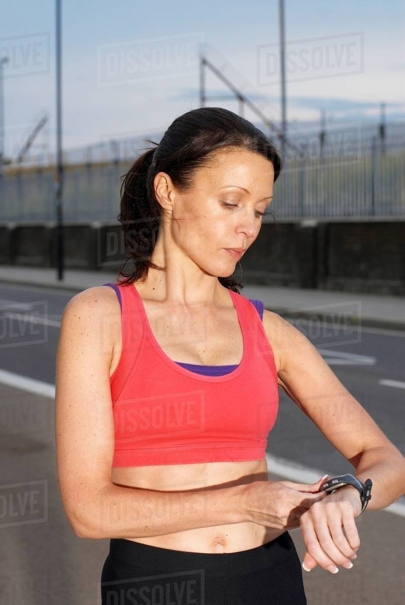 Runner checking her watch - Stock Photo - Dissolve