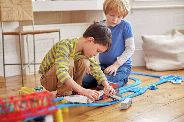 Two young boys playing with toy train set - Stock Photo - Dissolve