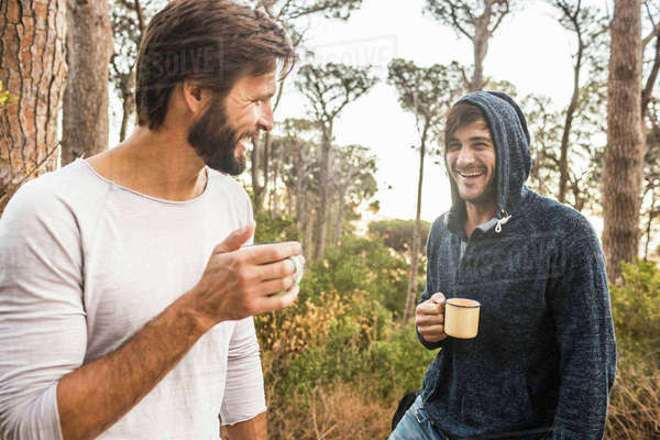 Two men drinking coffee and chatting in forest, Deer Park, Cape Town ...