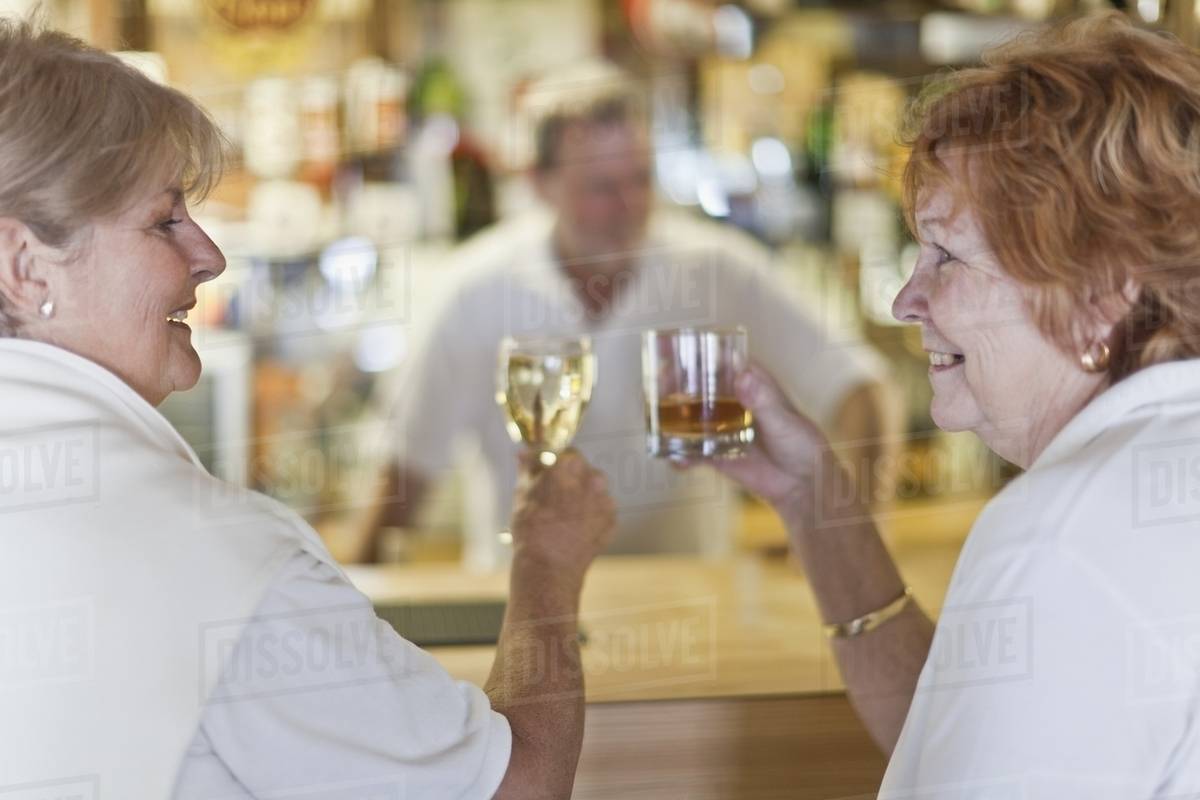 Older women toasting each other at bar - Royalty-free Stock Photo ...