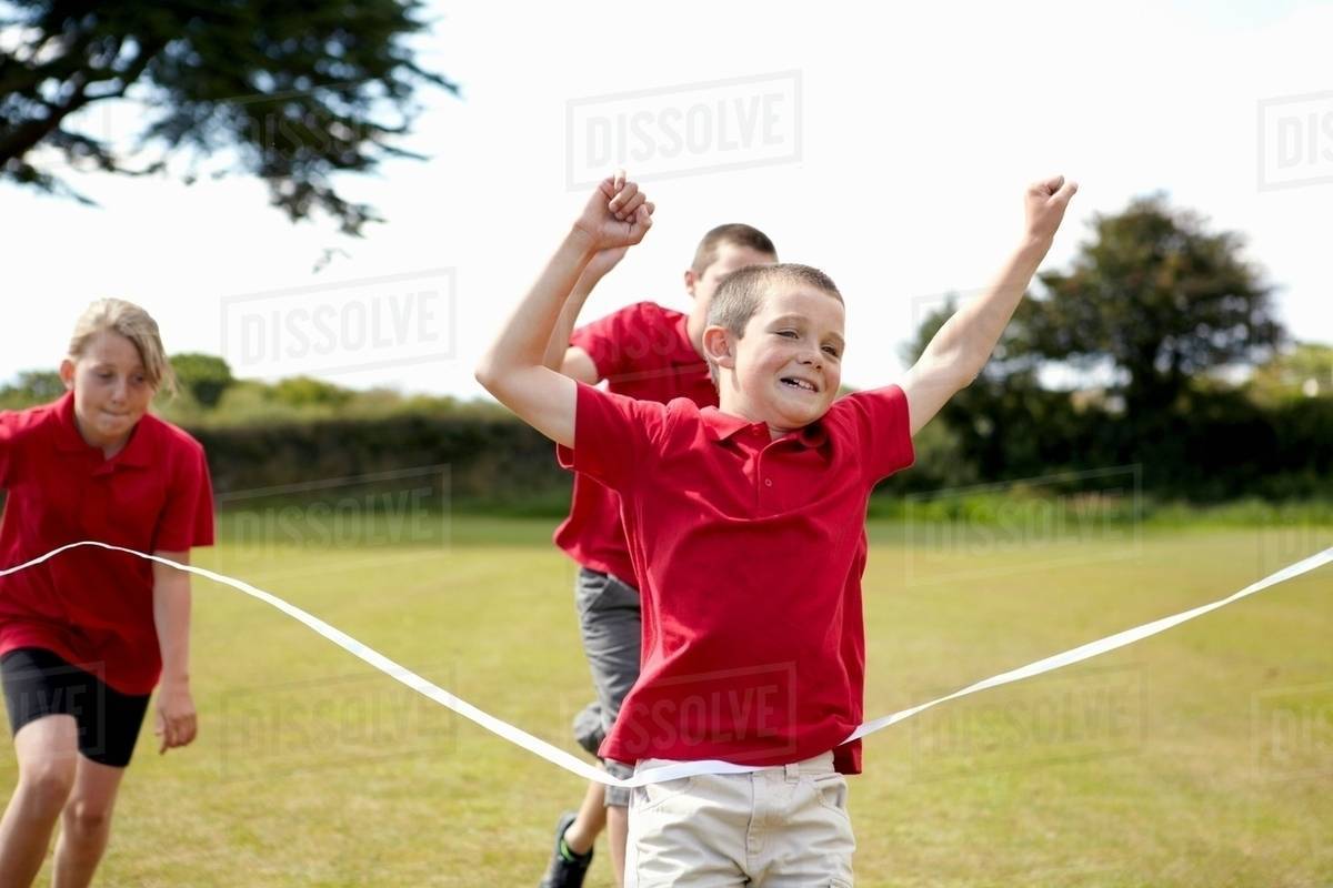Boy cheering and crossing finish line - Royalty-free Stock Photo | Dissolve