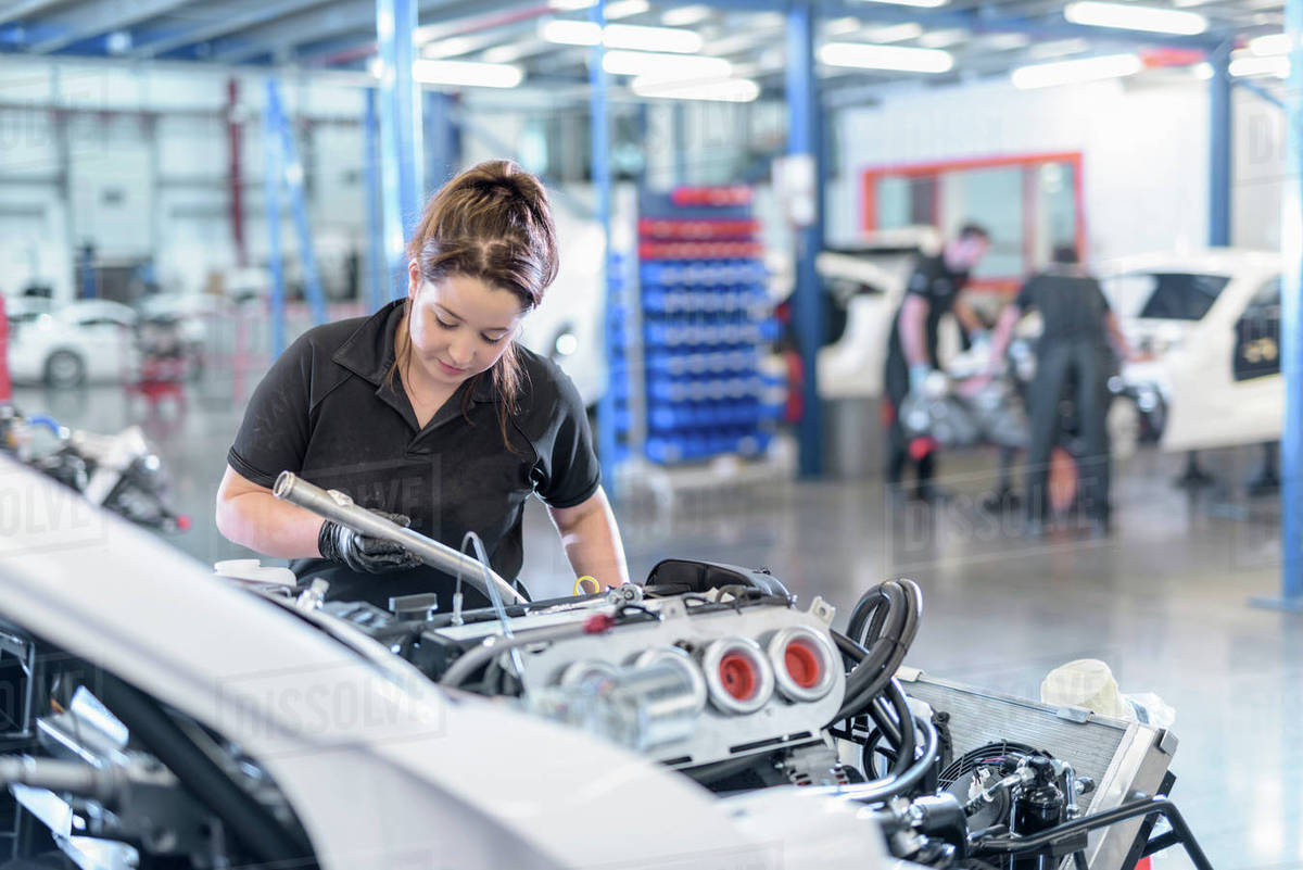 Female engineer assembles car in racing car factory - Stock Photo ...