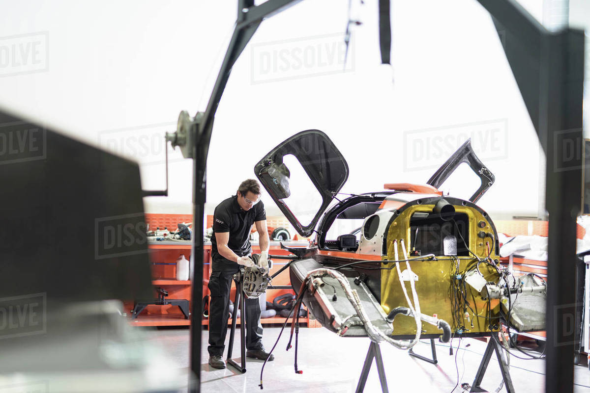 Engineer with car under construction in racing car factory - Stock ...