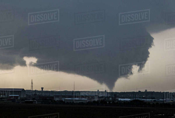 A cone tornado touches down from a very large wall cloud as it ...