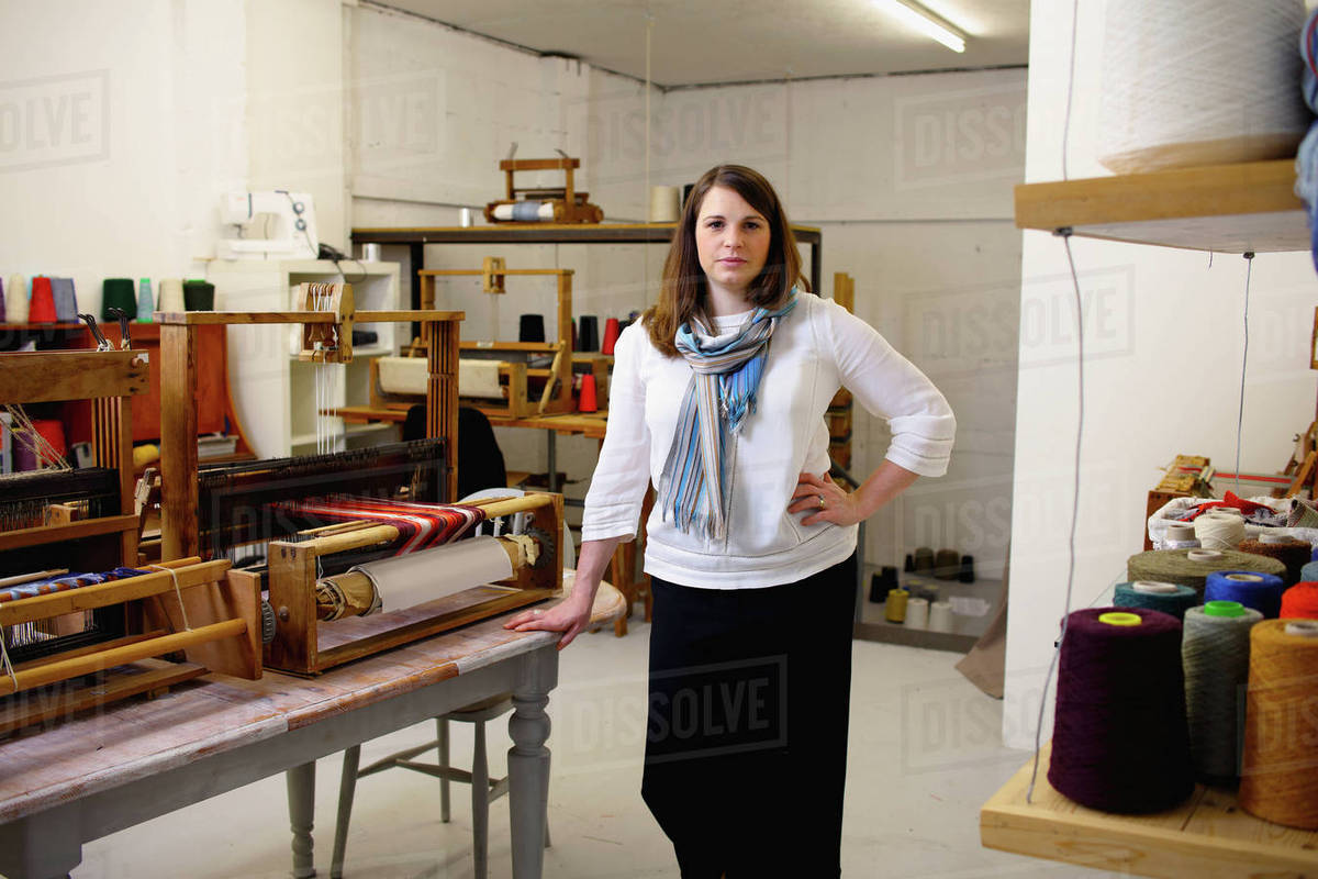 Woman in loom workshop looking at camera - Stock Photo - Dissolve