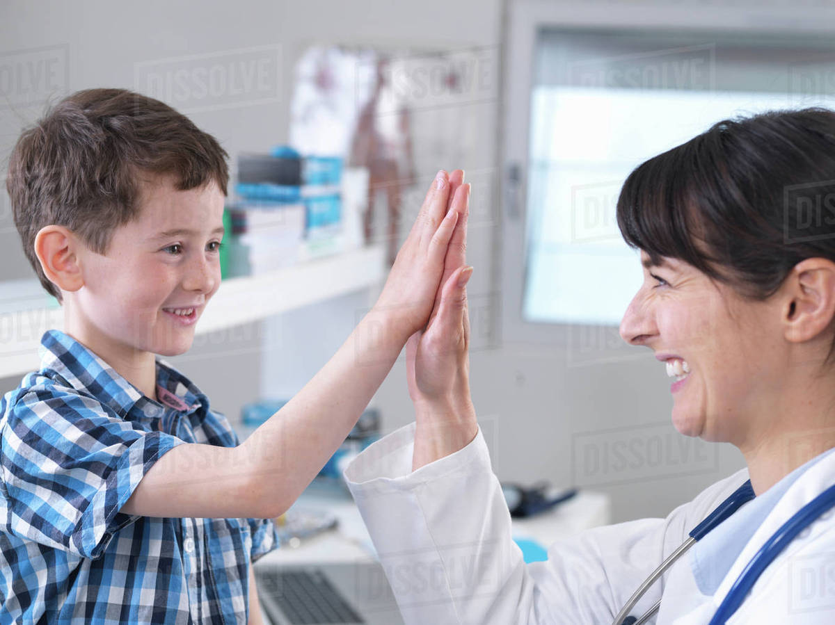 Doctor and boy doing high five in clinic - Royalty-free Stock Photo ...