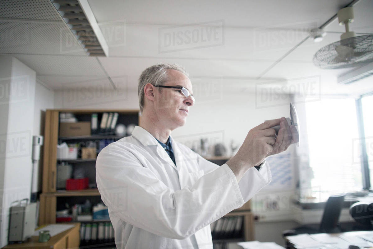 Male meteorologist examining equipment in weather station laboratory ...
