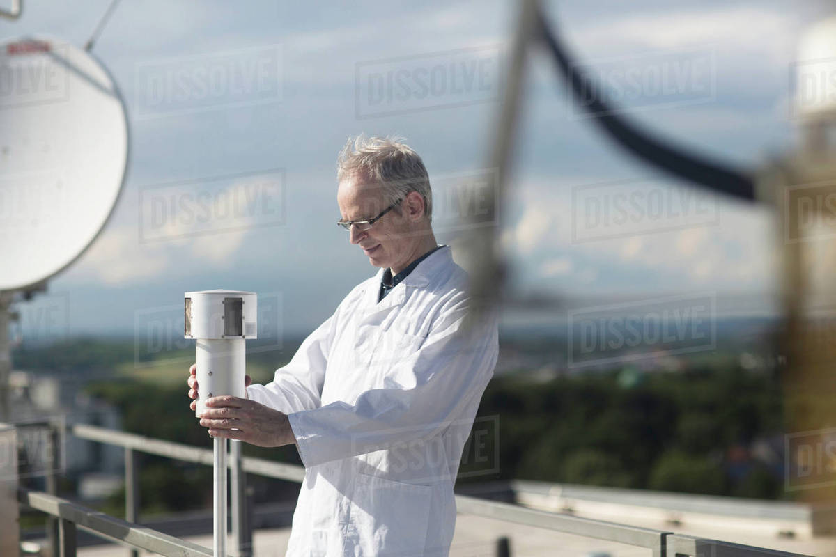Male meteorologist monitoring meteorological equipment at rooftop ...