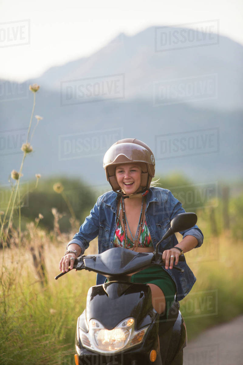 Happy young woman riding moped on rural road, Majorca, Spain - Stock ...