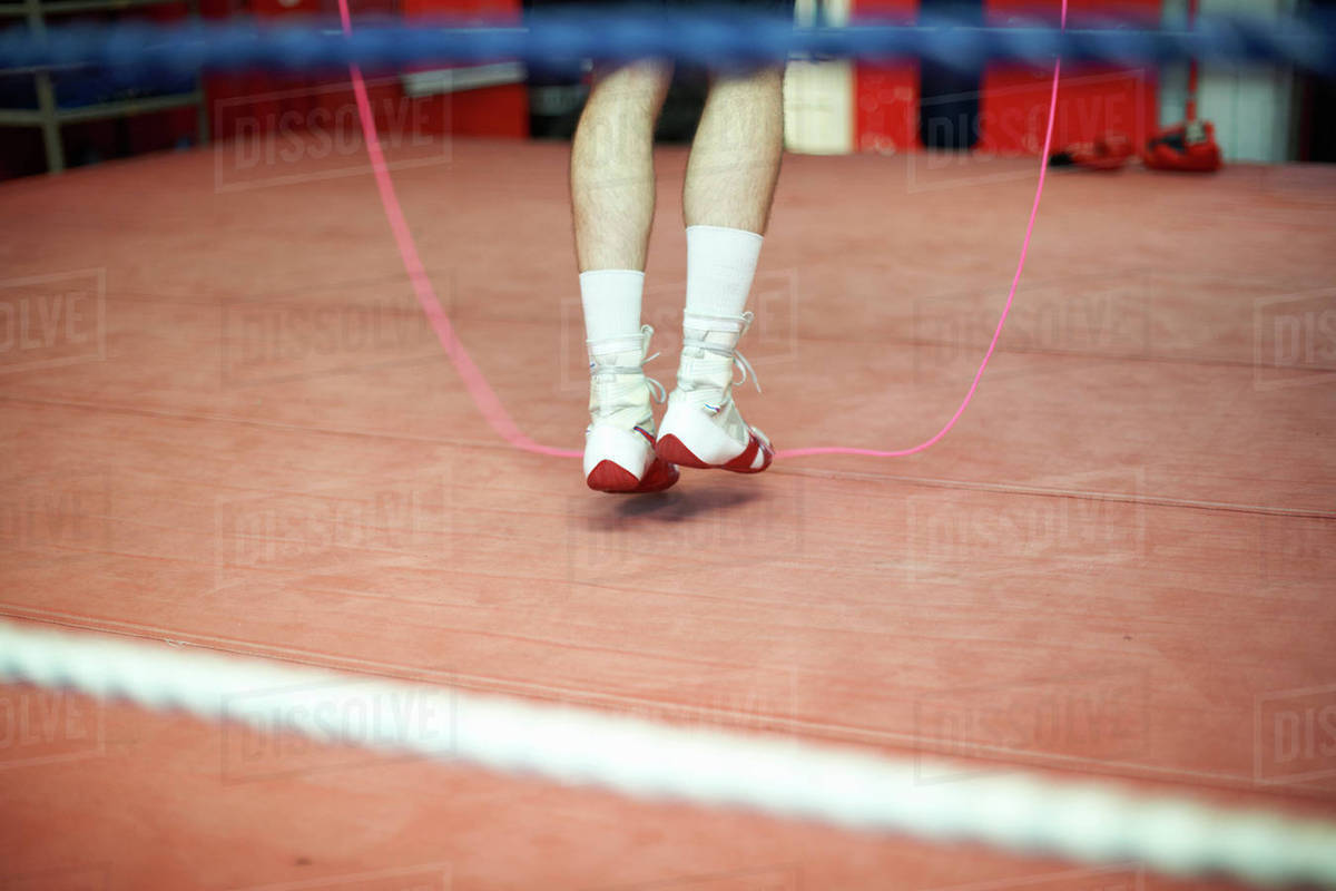 Boxer skipping in boxing ring, low section - Stock Photo - Dissolve