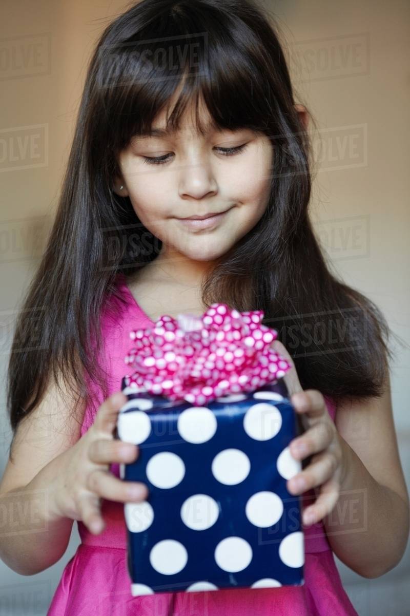 Girl holding wrapped gift - Royalty-free Stock Photo | Dissolve