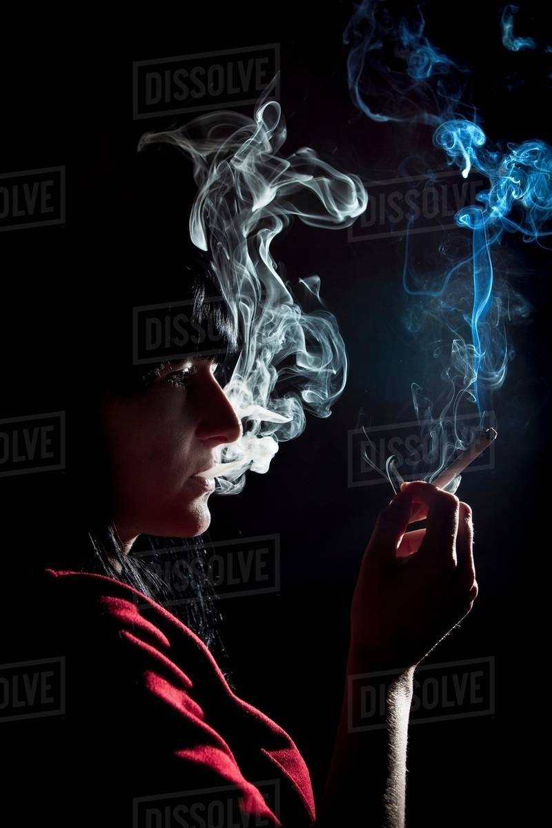 Illuminated profile of woman smoking - Royalty-free Stock Photo | Dissolve