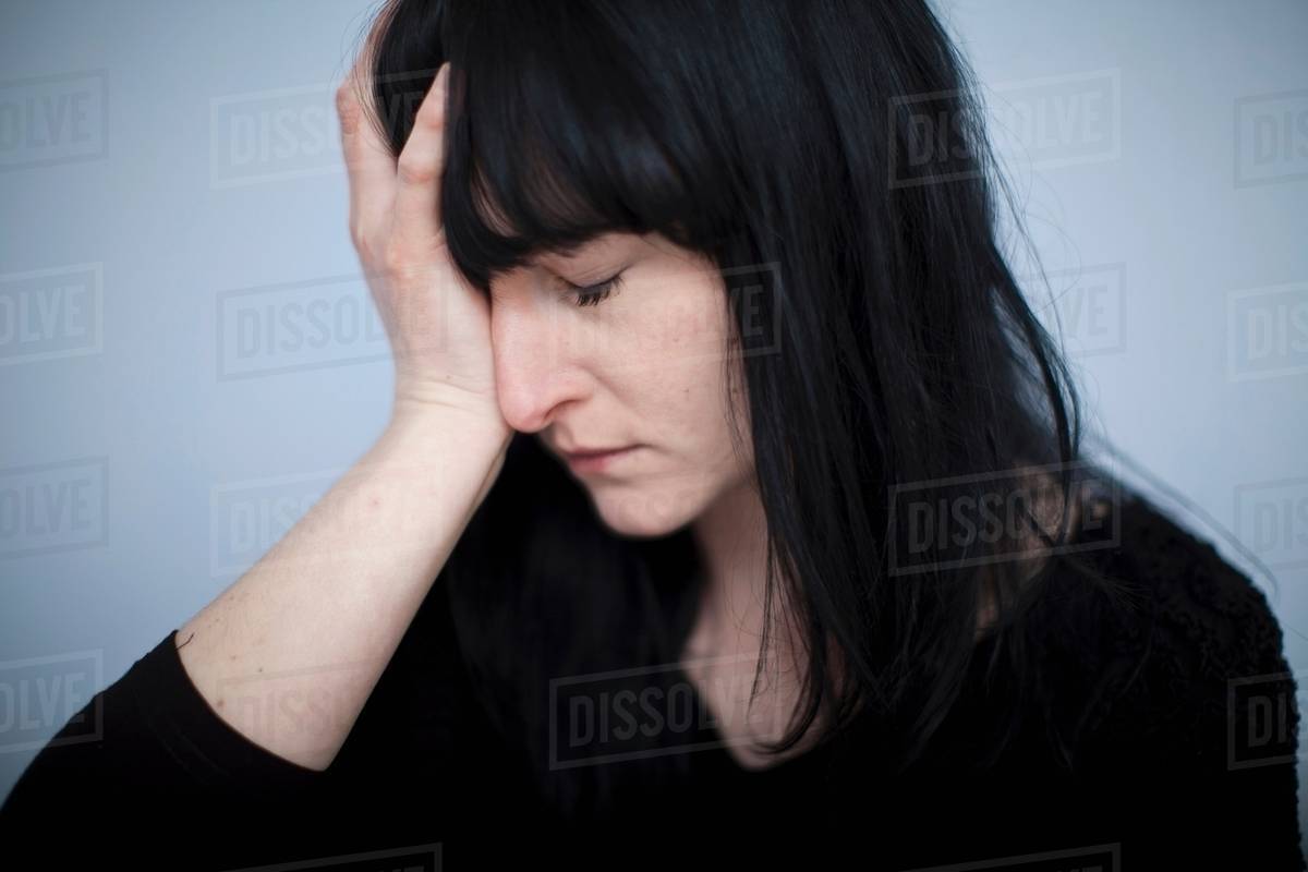 Close up of woman clutching her head - Royalty-free Stock Photo | Dissolve