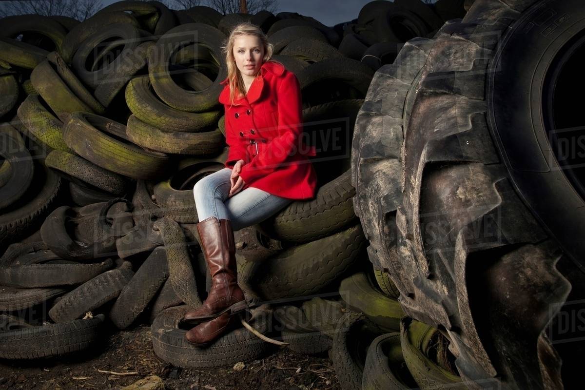 Teenage girl sitting on discarded tires - Royalty-free Stock Photo ...