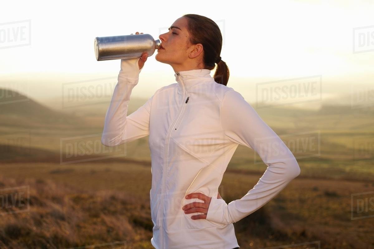 Runner drinking water in rural landscape - Stock Photo - Dissolve
