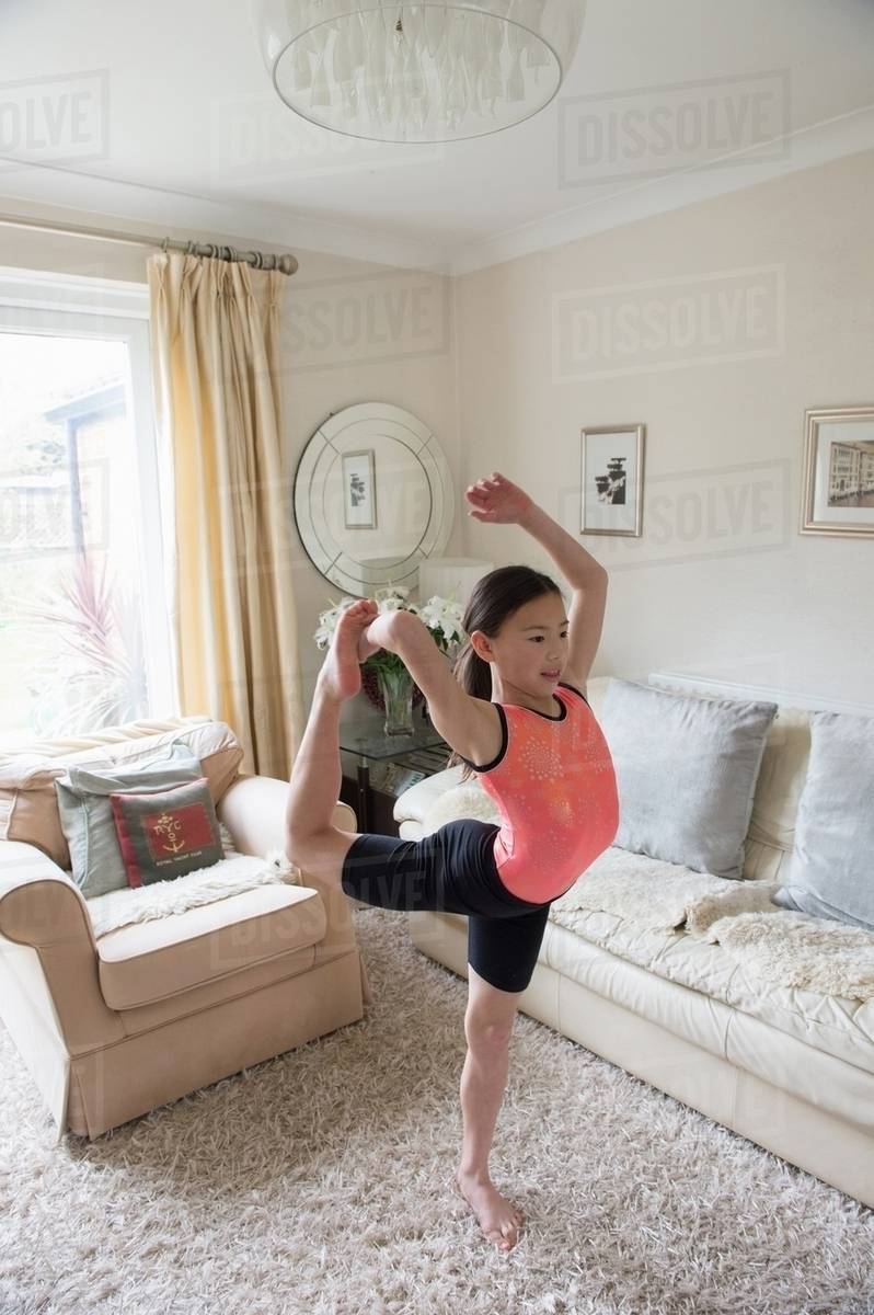 Girl practicing gymnastics on living room rug - Royalty-free Stock ...