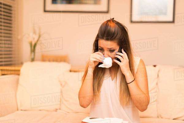 Young woman having telephone conversation, crying - Stock Photo - Dissolve