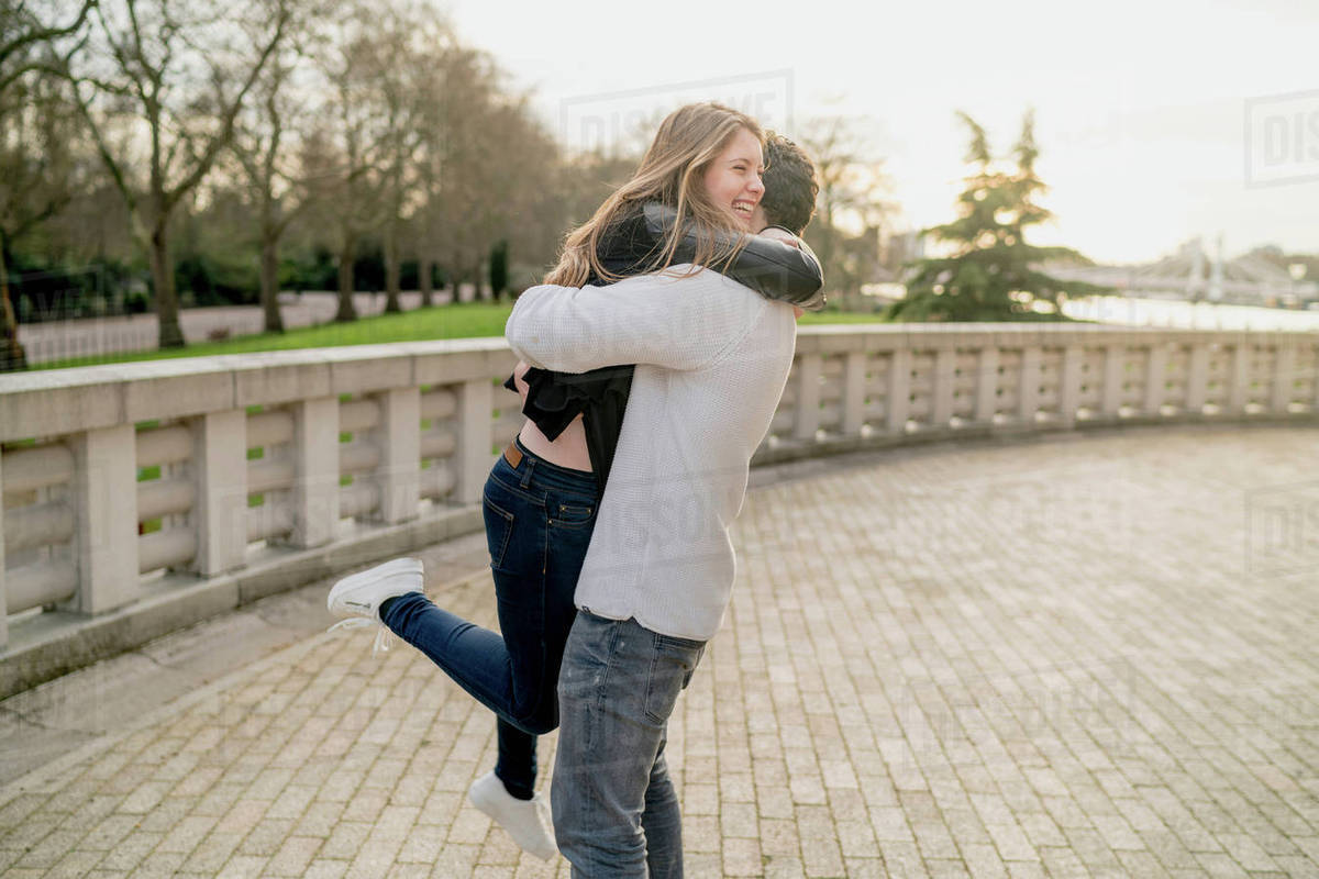 Romantic young man hugging girlfriend in Battersea Park, London, UK ...