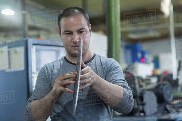 Man checking rotary blade in workshop - Stock Photo - Dissolve