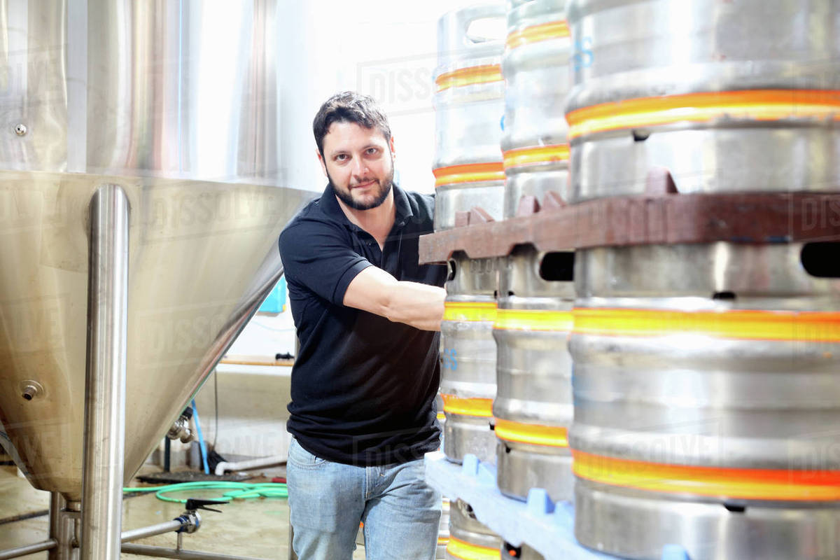 Worker in brewery organising beer barrels for delivery - Stock Photo ...