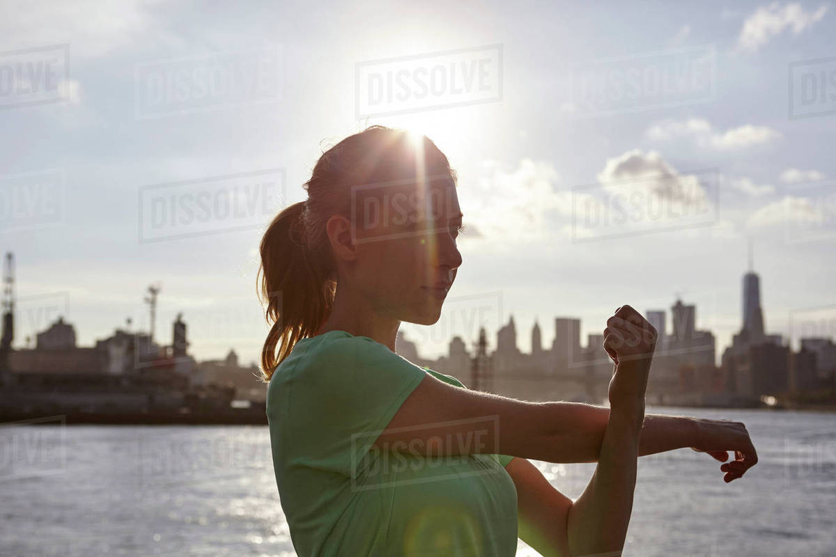 Woman by water stretching arm, Manhattan, New York, USA - Royalty-free ...