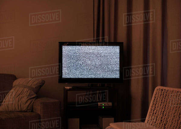 Darkened living room with static noise on TV screen - Stock Photo ...