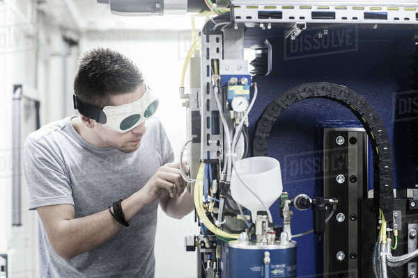 Engineer, wearing safety goggles, working in engineering plant ...