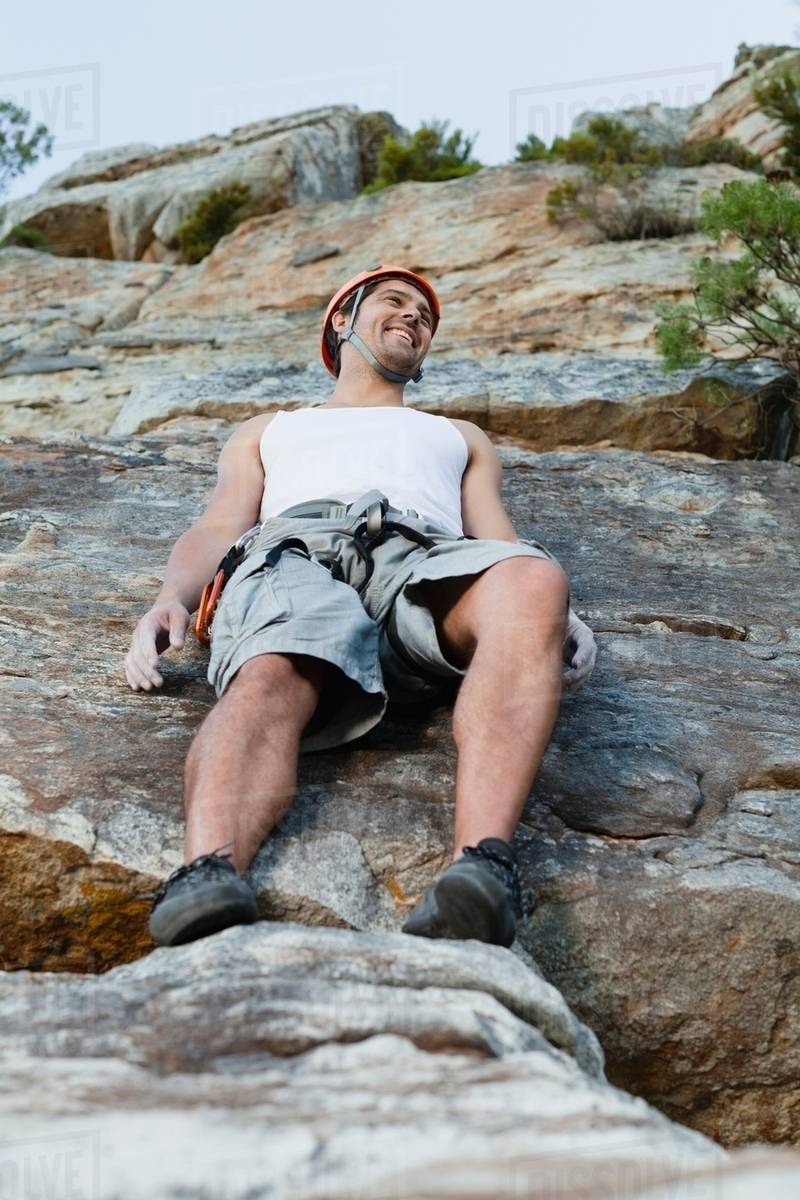 Climber leaning on steep rock face - Stock Photo - Dissolve