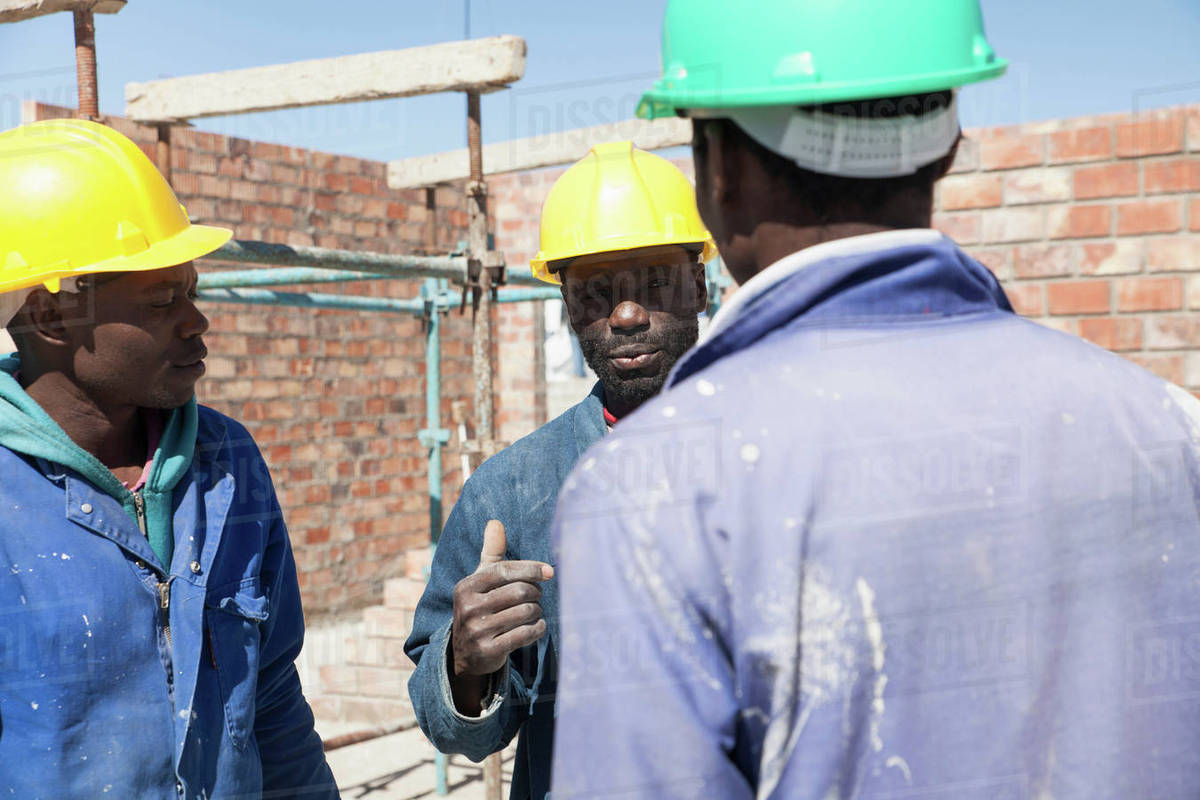 Builders talking on construction site - Royalty-free Stock Photo | Dissolve