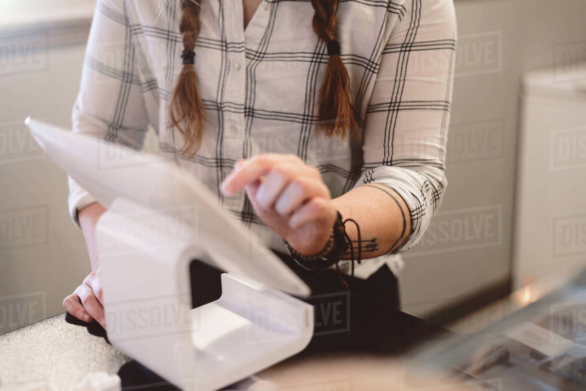 Cashier using cash register in cafe - Royalty-free Stock Photo | Dissolve