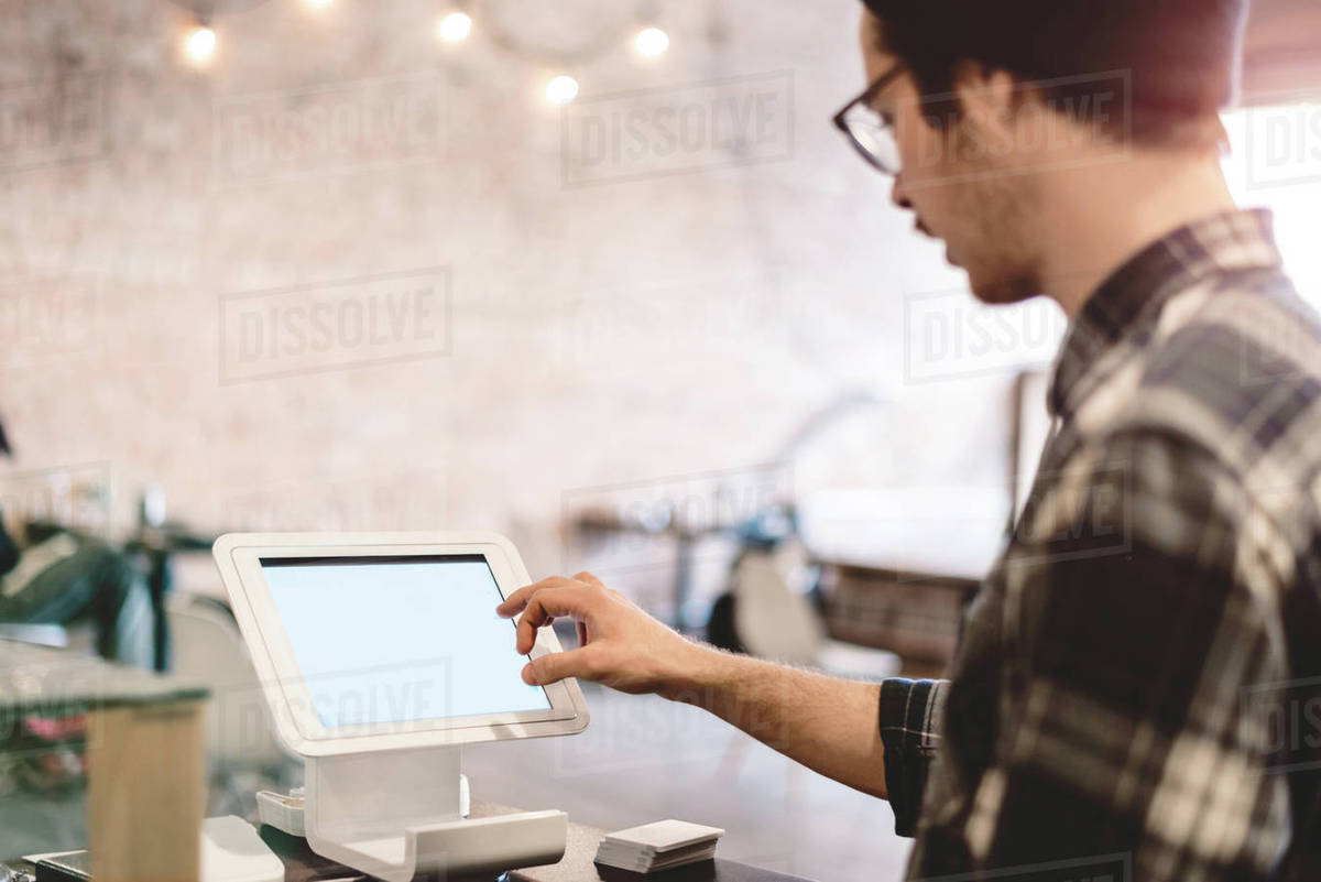 Cashier using cash register in cafe - Royalty-free Stock Photo | Dissolve