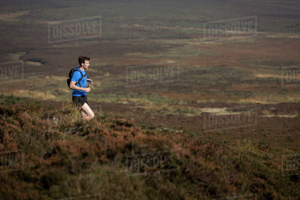 Male runner running down moorland - Royalty-free Stock Photo | Dissolve
