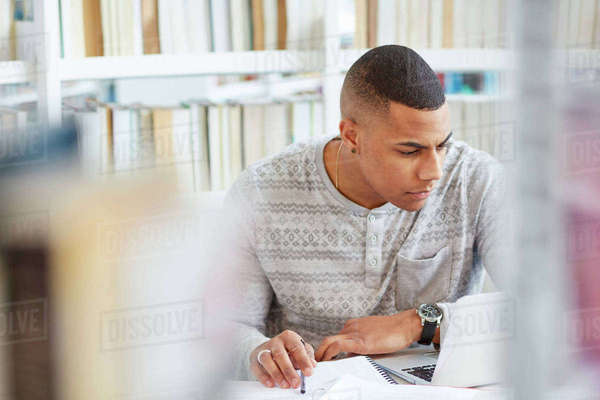 University student working in library - Stock Photo - Dissolve